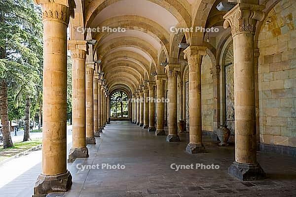 Long, minimalist portico with symmetrical stone arches in a cool ...