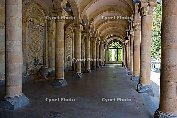 Historic colonnade with symmetrical stone arches in a cool interior ...