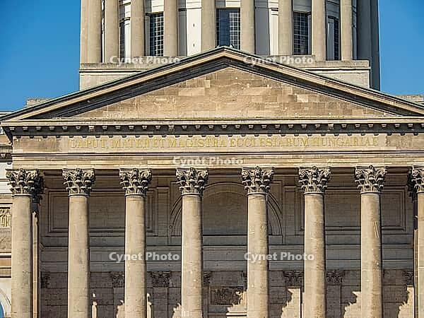 A monumental cathedral with classical columns and Latin inscription ...